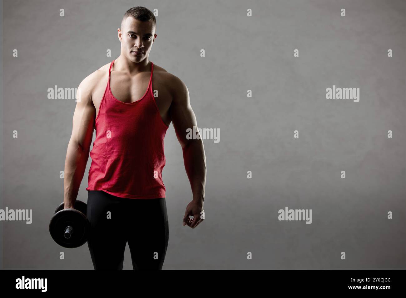 Fit athlete doing standing dumbbell curls for training his biceps ...