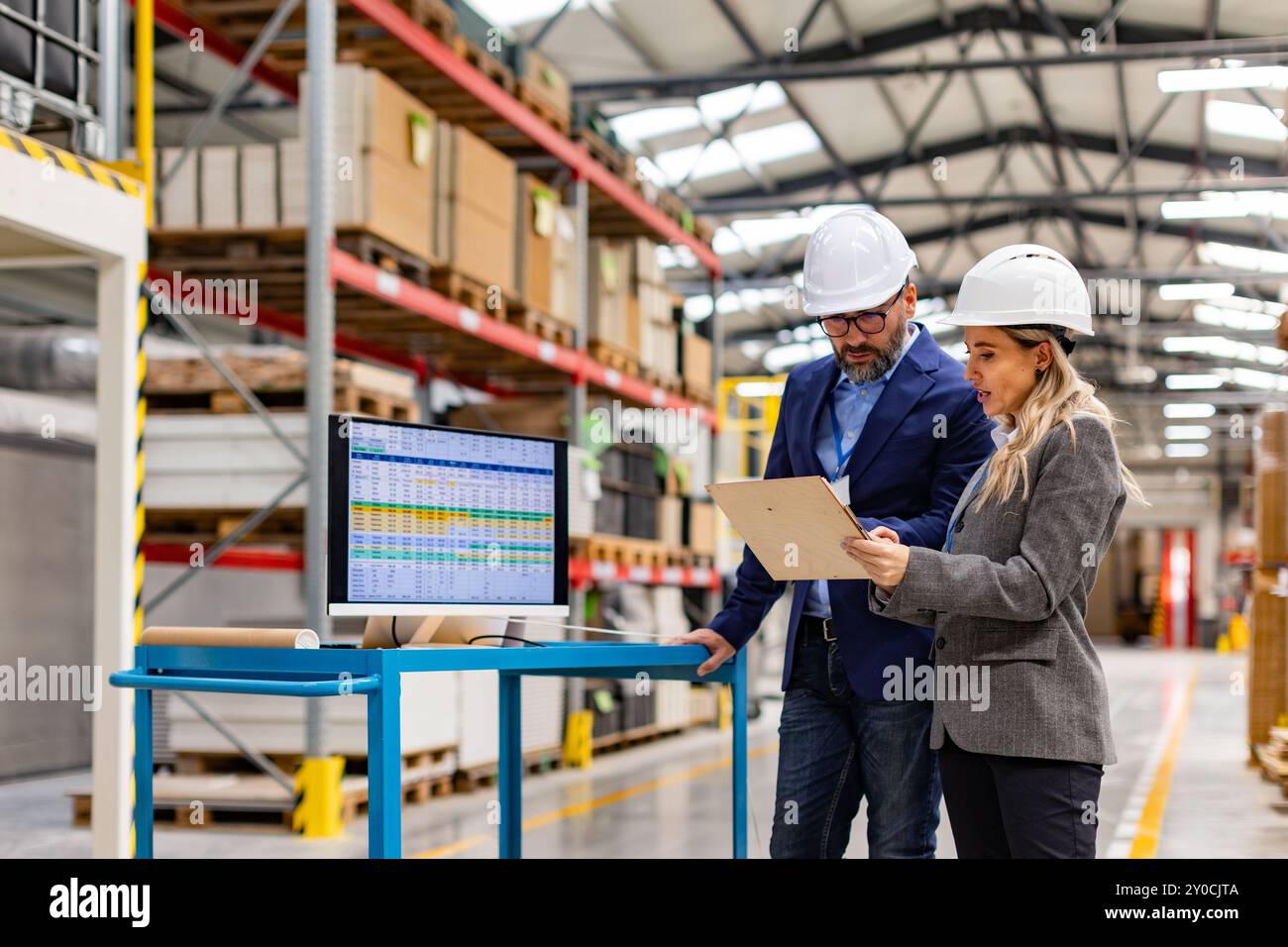 Female engineer and male project manager standing in modern industrial ...