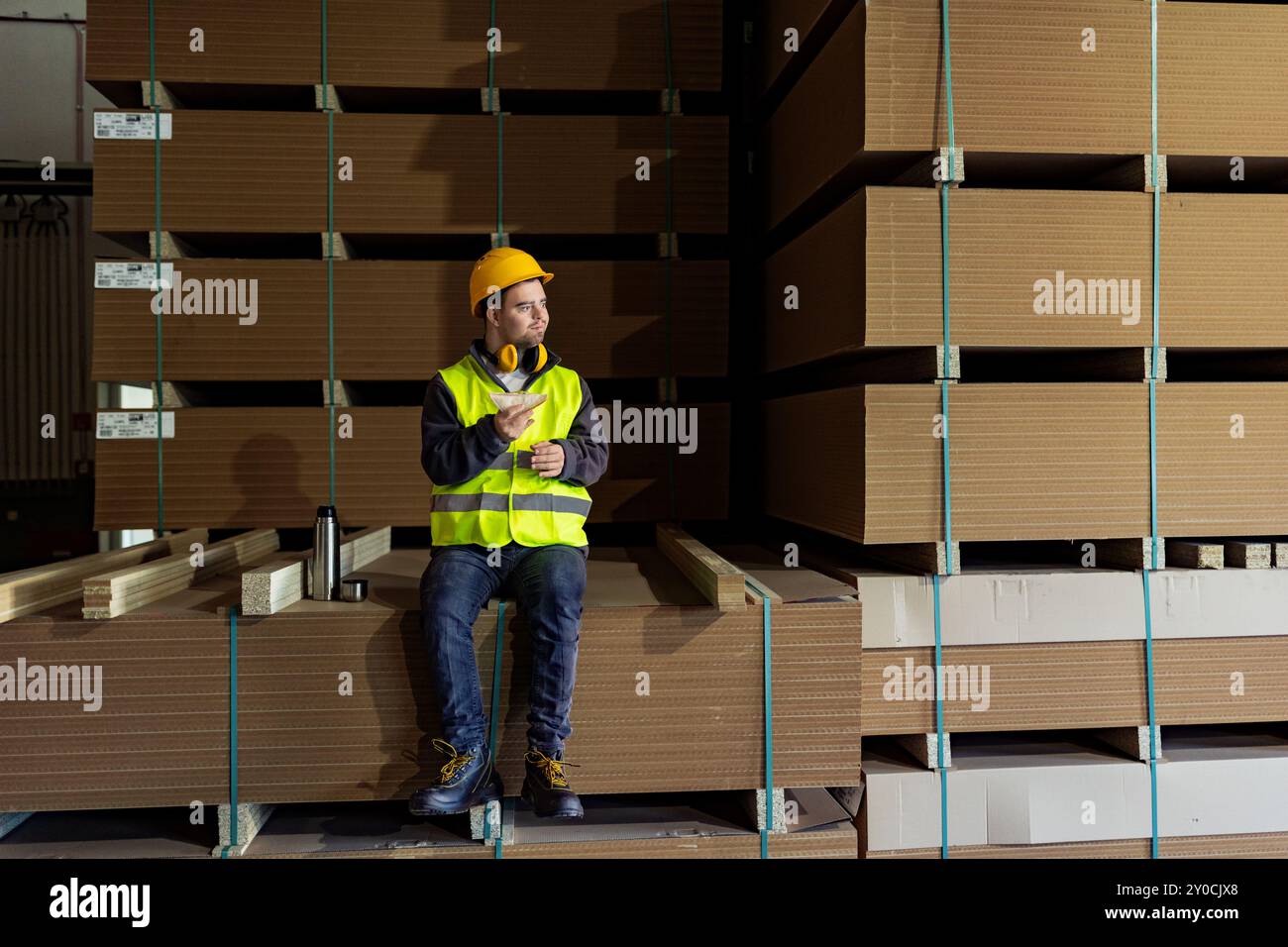 Worker with Down syndrome having break in factory, warehouse, eating ...
