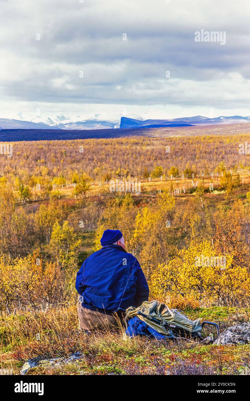 Man sitting looking at the view in a beautiful mountain landscape in ...