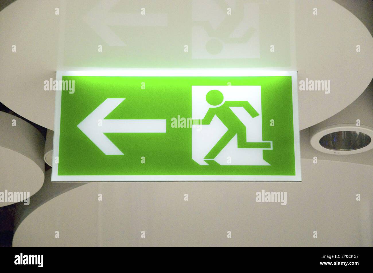 Green emergency exit sign in a station Stock Photo - Alamy