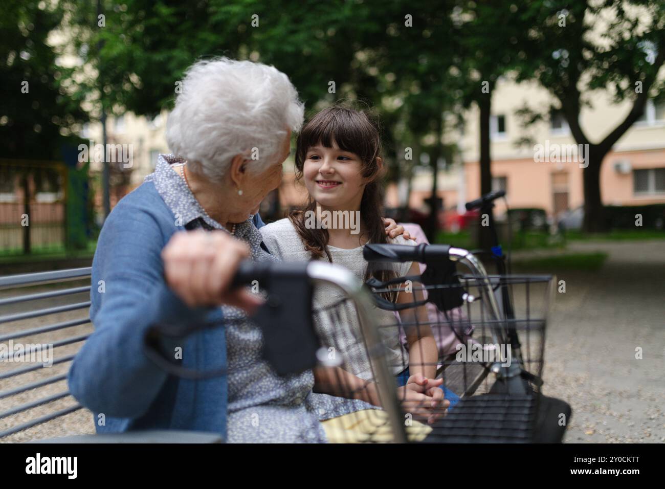 Grandma with walker spending time with granddaughter in city park ...
