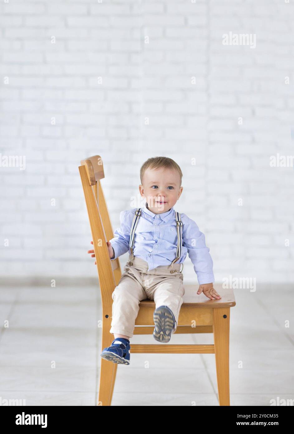 Beautiful adorable laughing baby boy sitting on the chair. Smiling blue ...