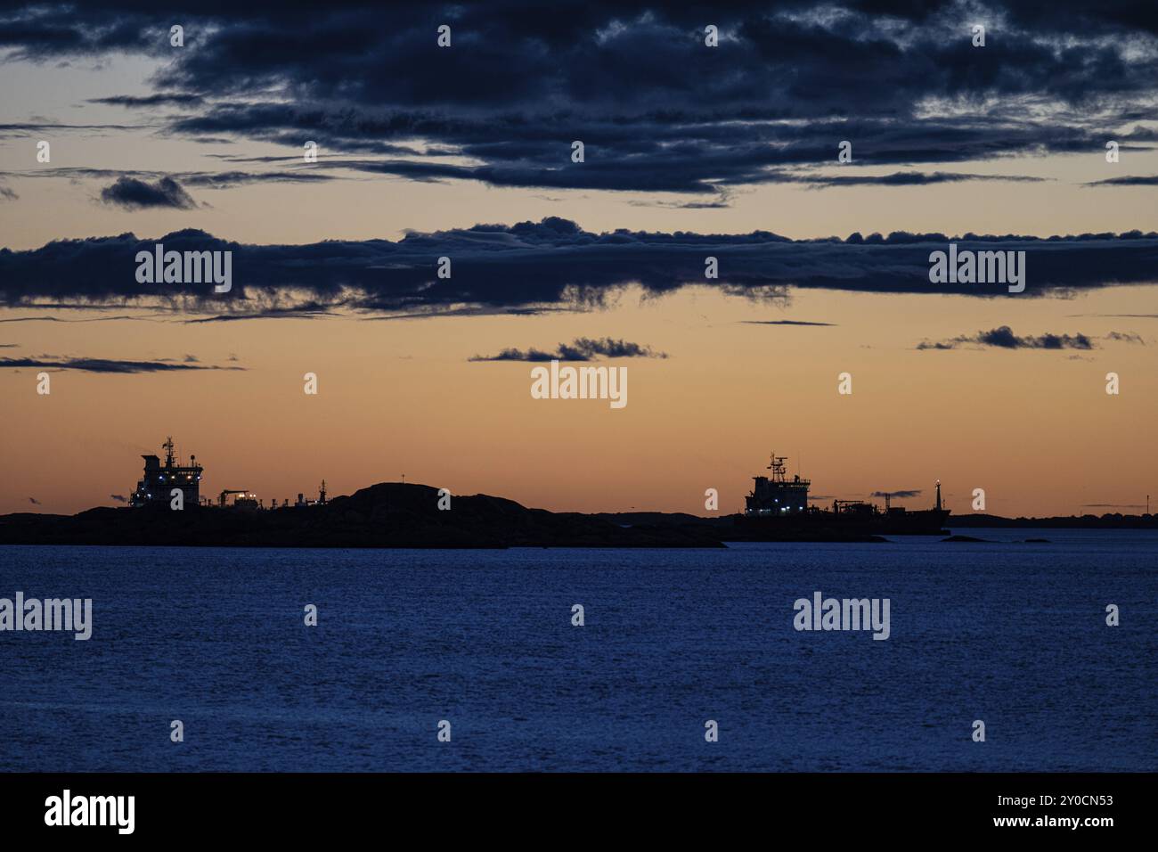 Silhouette of tanker ships in sunset light Stock Photo - Alamy