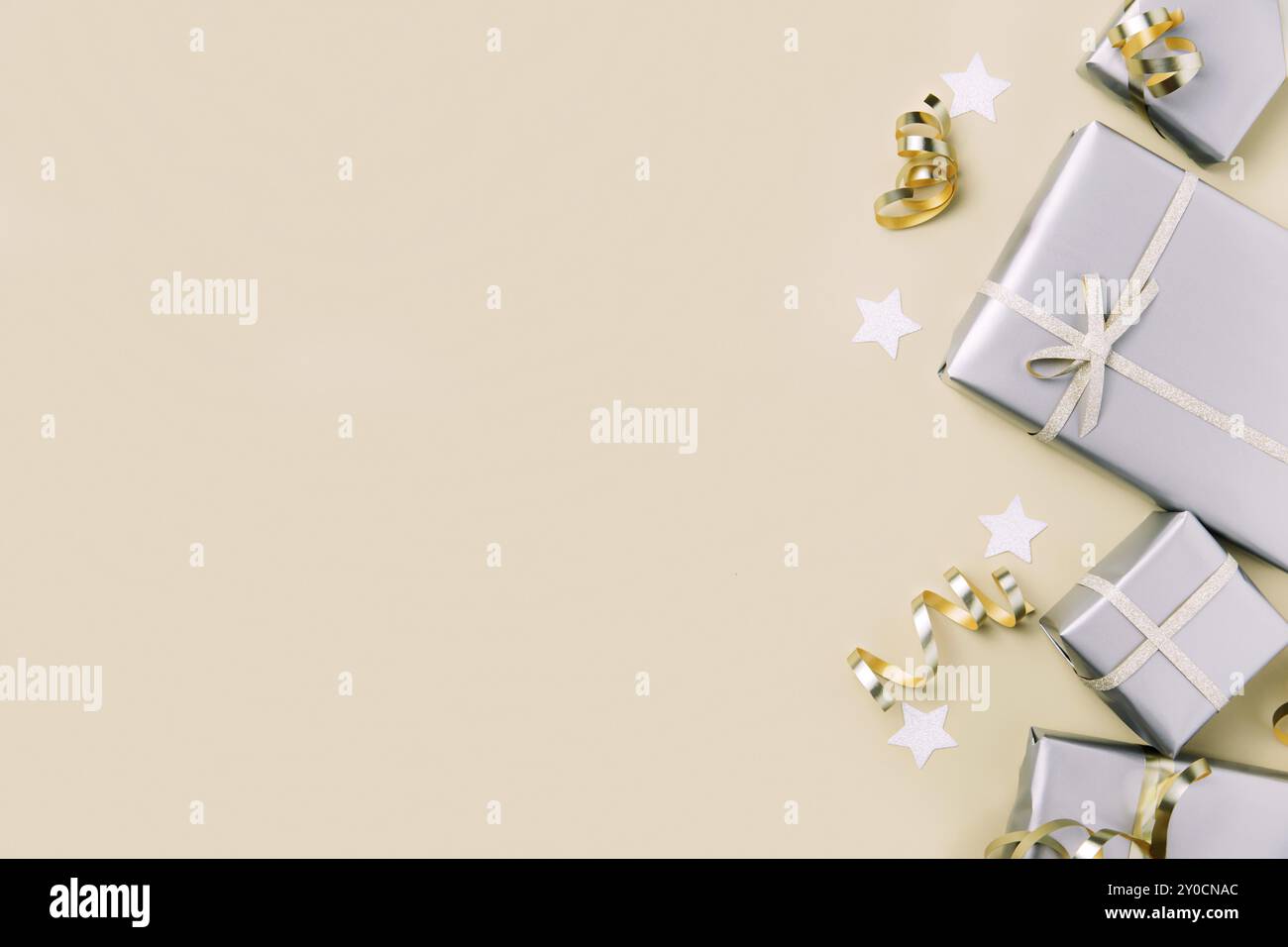 Light beige or yellow flat lay background with gift boxes in glossy ...
