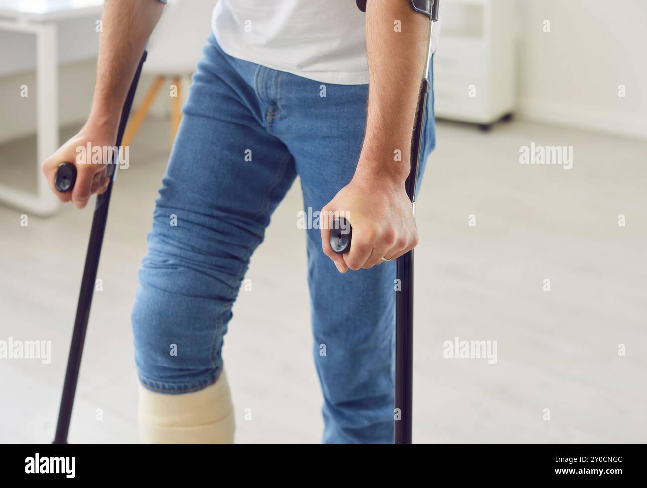 Broken leg or foot injury man walking on crutches with bandaged leg at ...