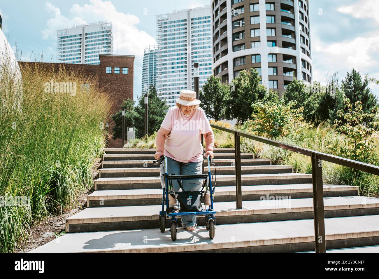 Elderly woman walking down the stairs with rollator, running errands ...