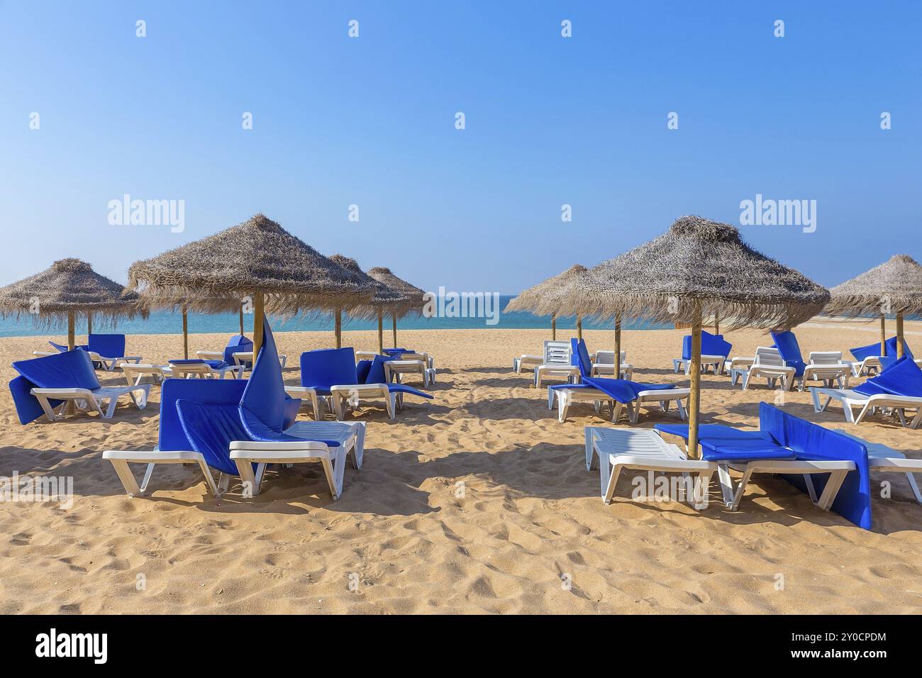 Group wicker beach parasols and blue beach beds at portuguese coast ...