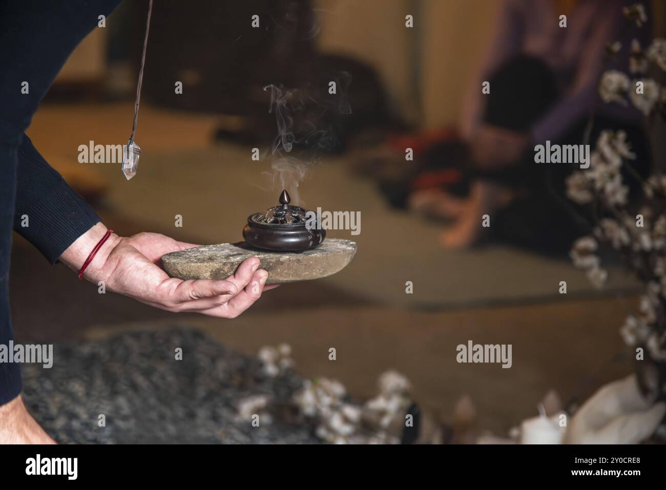 Incense smoke rises, purifying the place. A person performs a spiritual ...