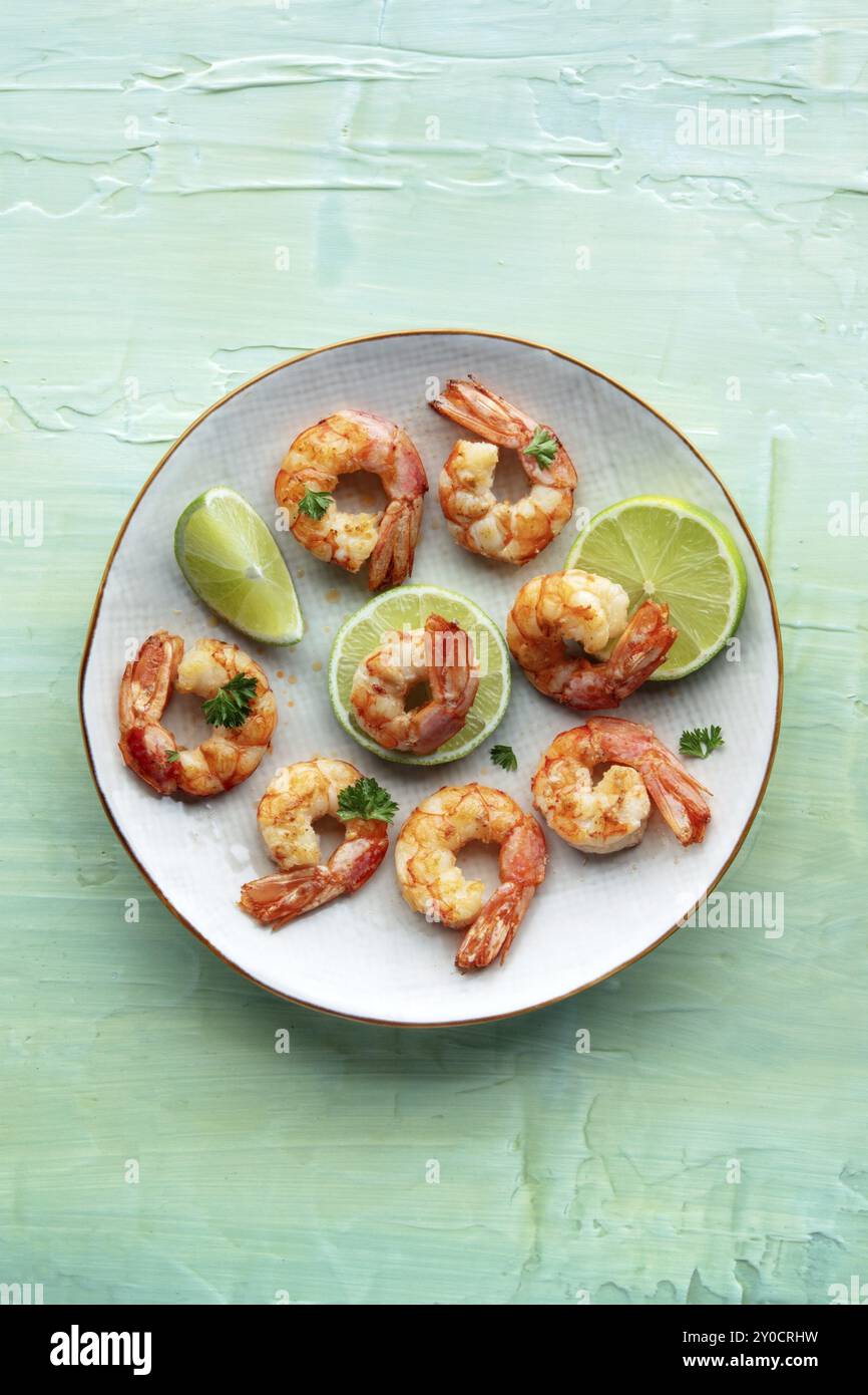 Shrimps, shot from above on a teal blue background. Cooked shrimp with ...