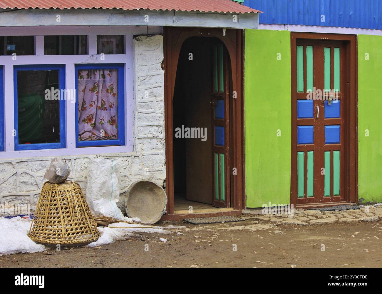 Colorful painted doors and facade. Braided basked used for transporting ...