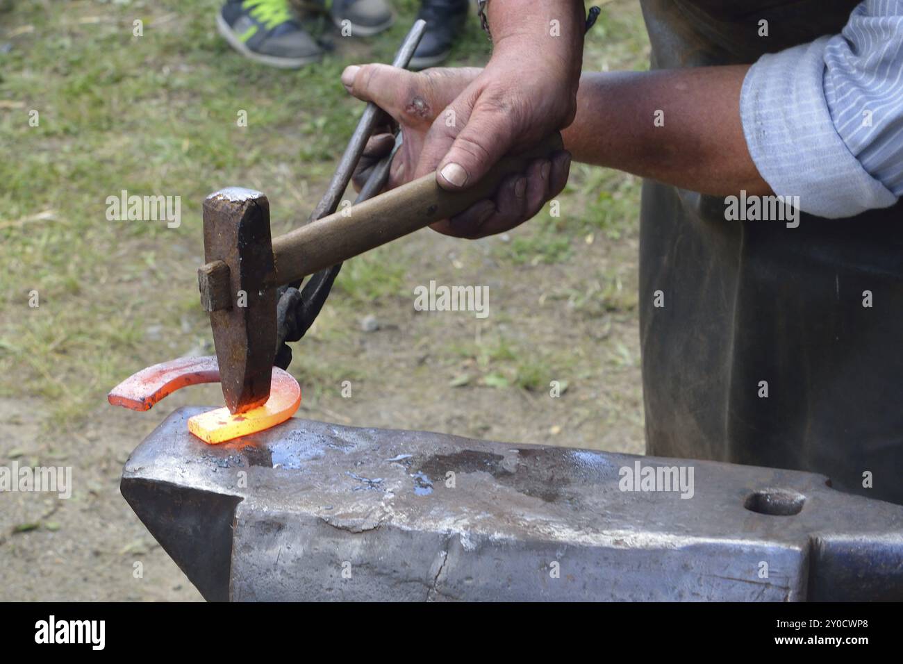 Forging horseshoes, Blacksmith forges a horseshoe Stock Photo - Alamy