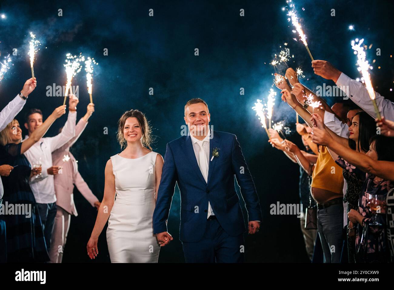 cold fire from cake candles and fireworks in the hands of people around ...