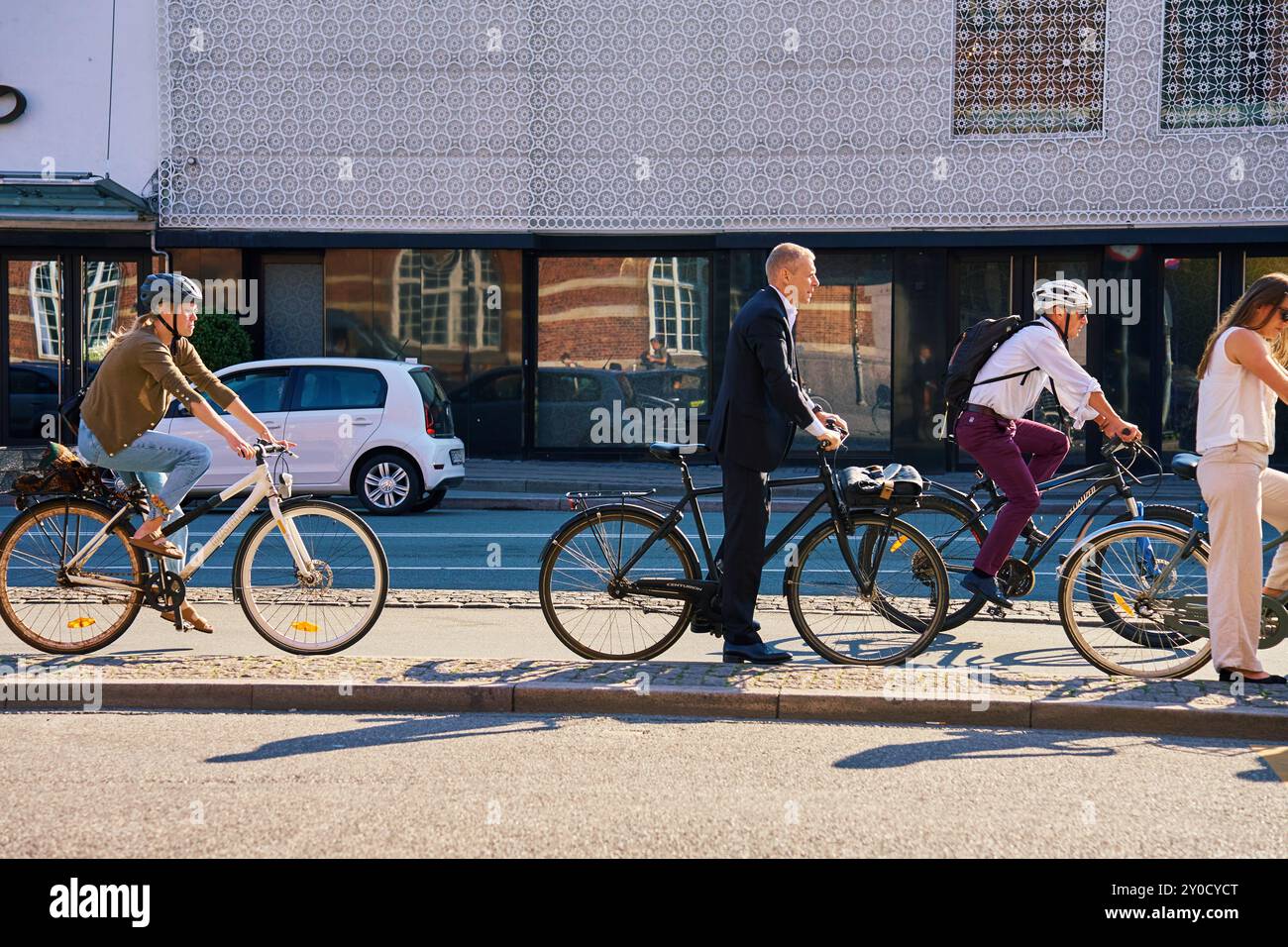 People riding bicycles in bike lane. Bike traffic at city street in ...
