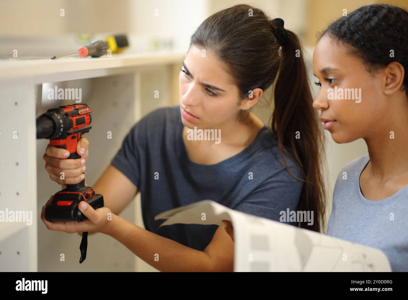 Interracial Roommates Installing Furniture In The Kitchen With 5411