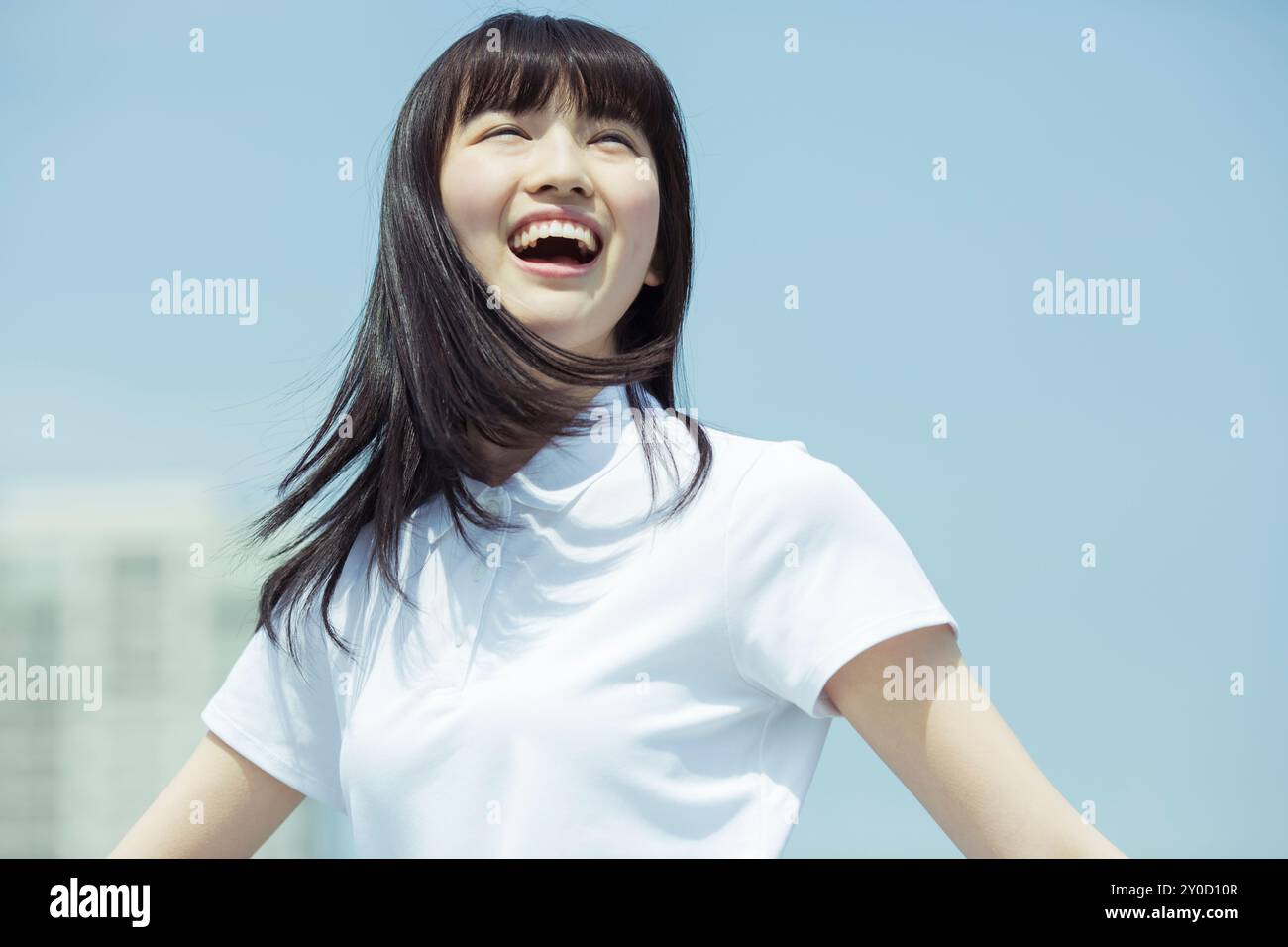 A smiling high school girl looking up at the sky Stock Photo - Alamy