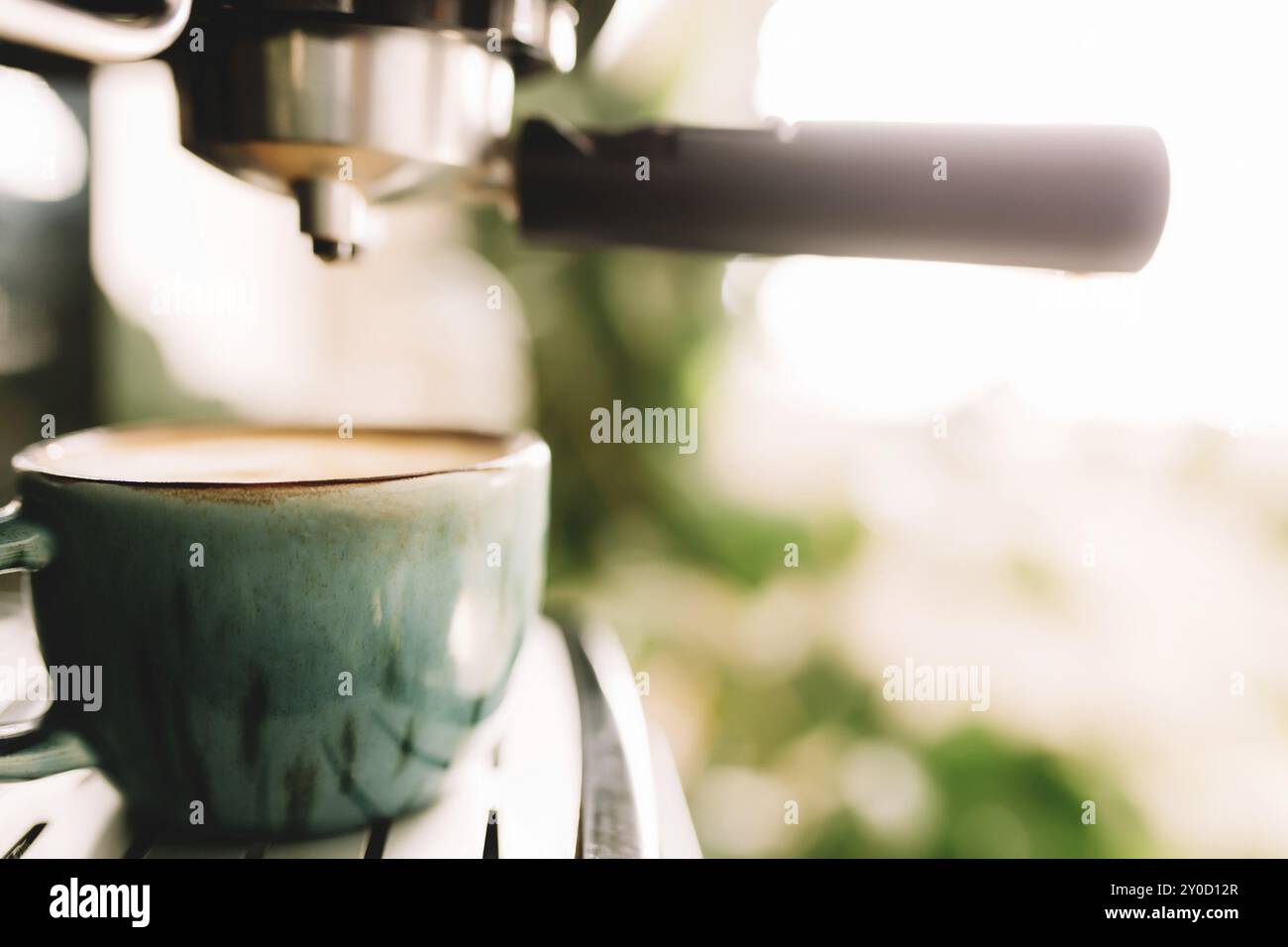 Green cup of coffee at the coffee maker machine, coffee time. Blurred ...