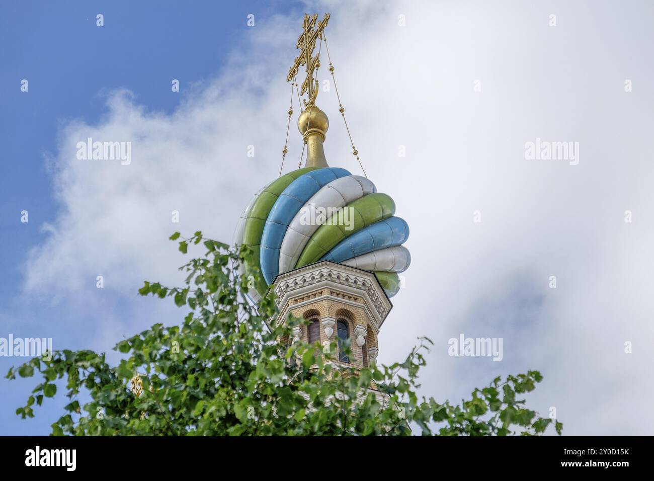 Golden cross above a colourful, onion-shaped dome in front of a blue ...