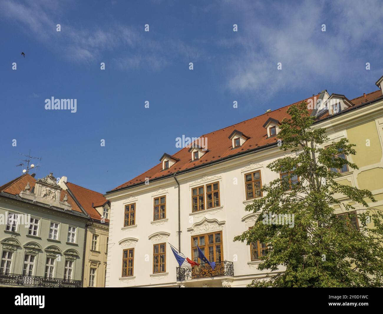 Historic buildings with red roofs and windows against a blue sky ...