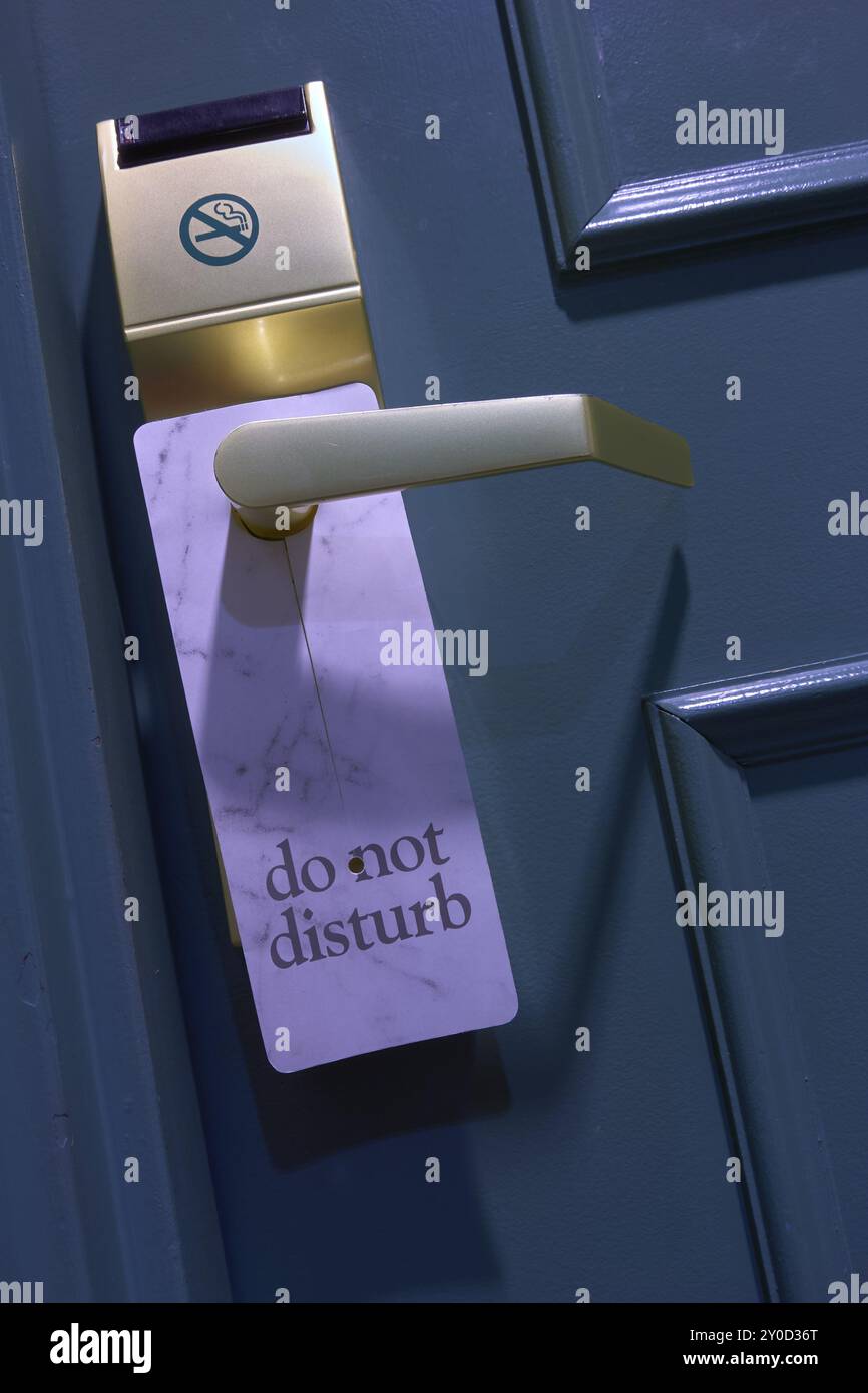 Blue painted door with 'Do Not Disturb' sign and gold-coloured handle ...