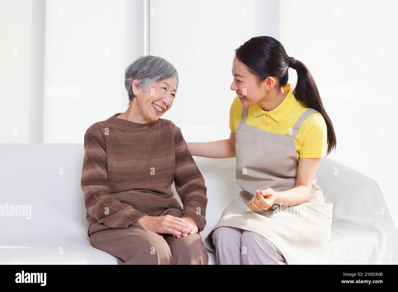An elderly woman having a conversation with a caregiver Stock Photo - Alamy