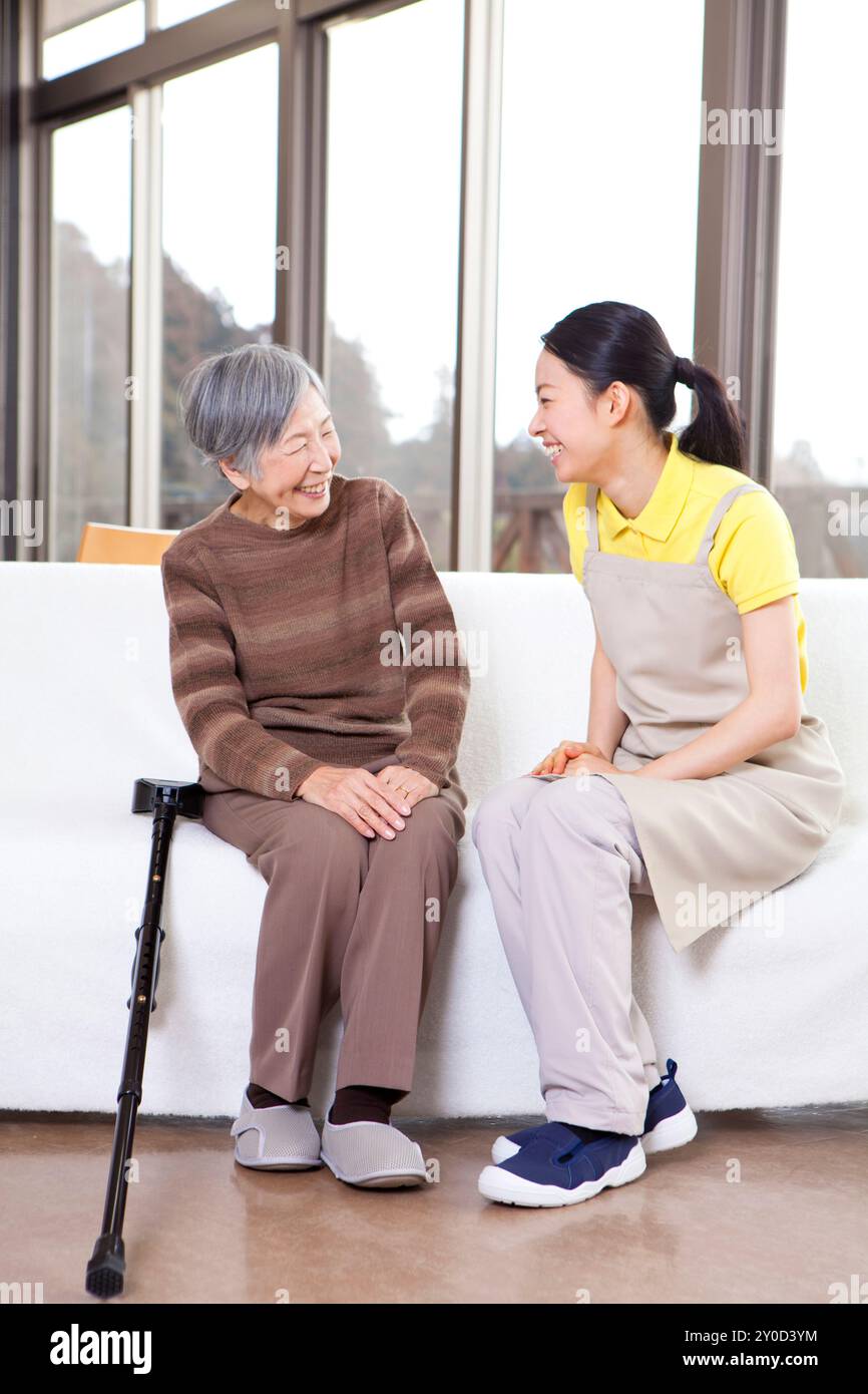 An elderly woman having a conversation with a caregiver Stock Photo - Alamy