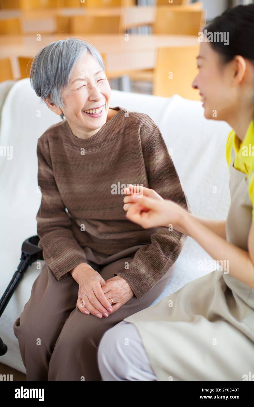 An elderly woman having a conversation with a caregiver Stock Photo - Alamy