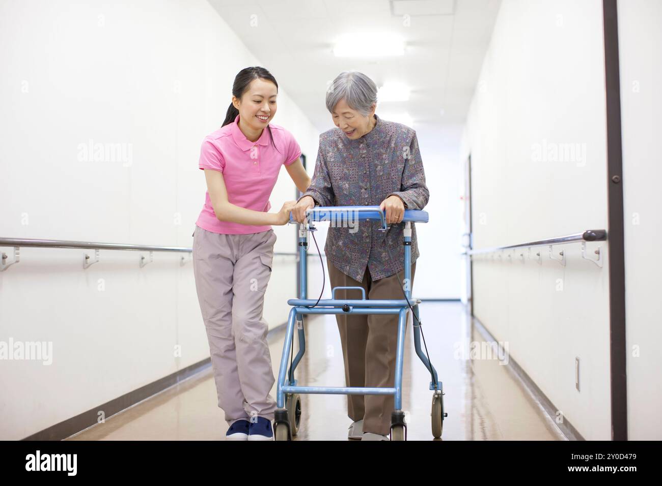 An elderly woman undergoing gait training with a woman caregiver by her side Stock Photo - Alamy