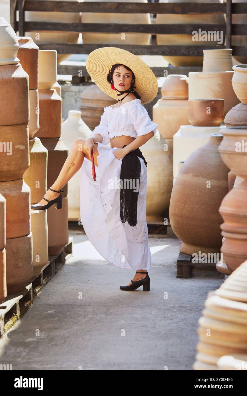 Young woman with dark hair, in white dress, poses gracefully among ...