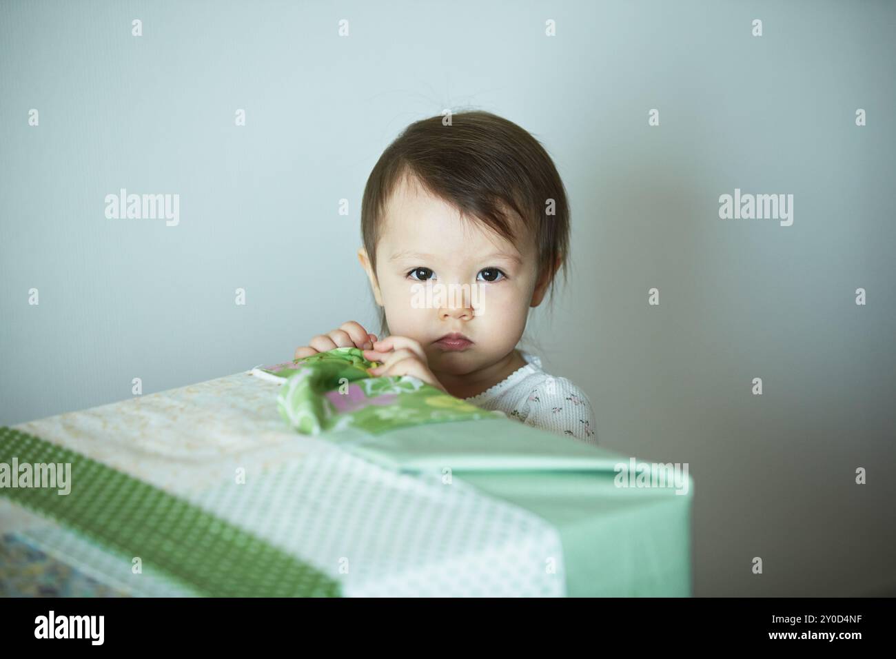 A baby girl touching a gift box Stock Photo - Alamy