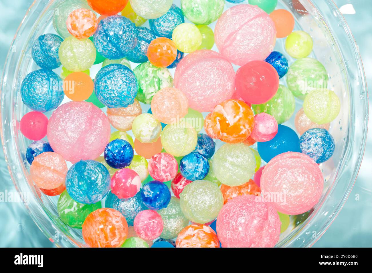 A large number of colorful super balls floating on glass bowl Stock ...