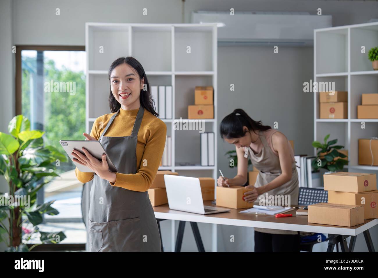 Women using digital tools for ecommerce packaging tasks Stock Photo - Alamy