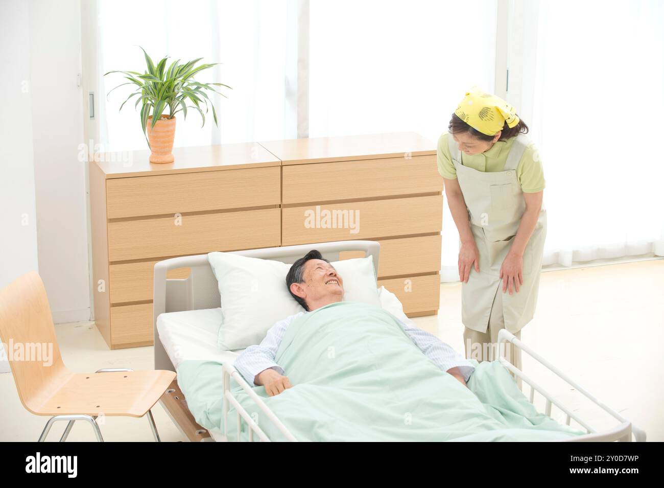 An elderly in bed and a care helper Stock Photo - Alamy