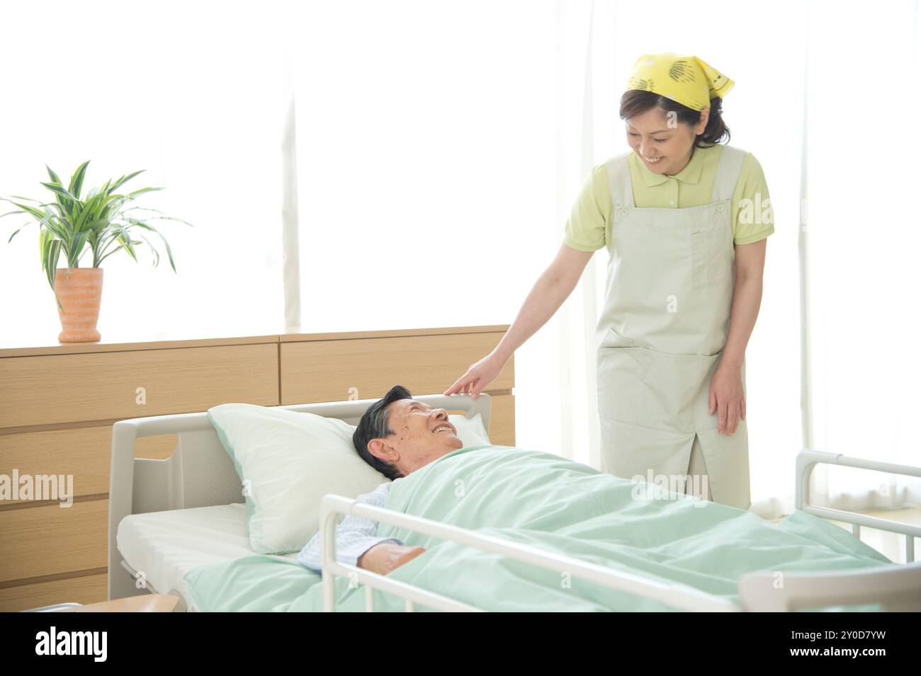 An elderly in bed and a care helper Stock Photo - Alamy
