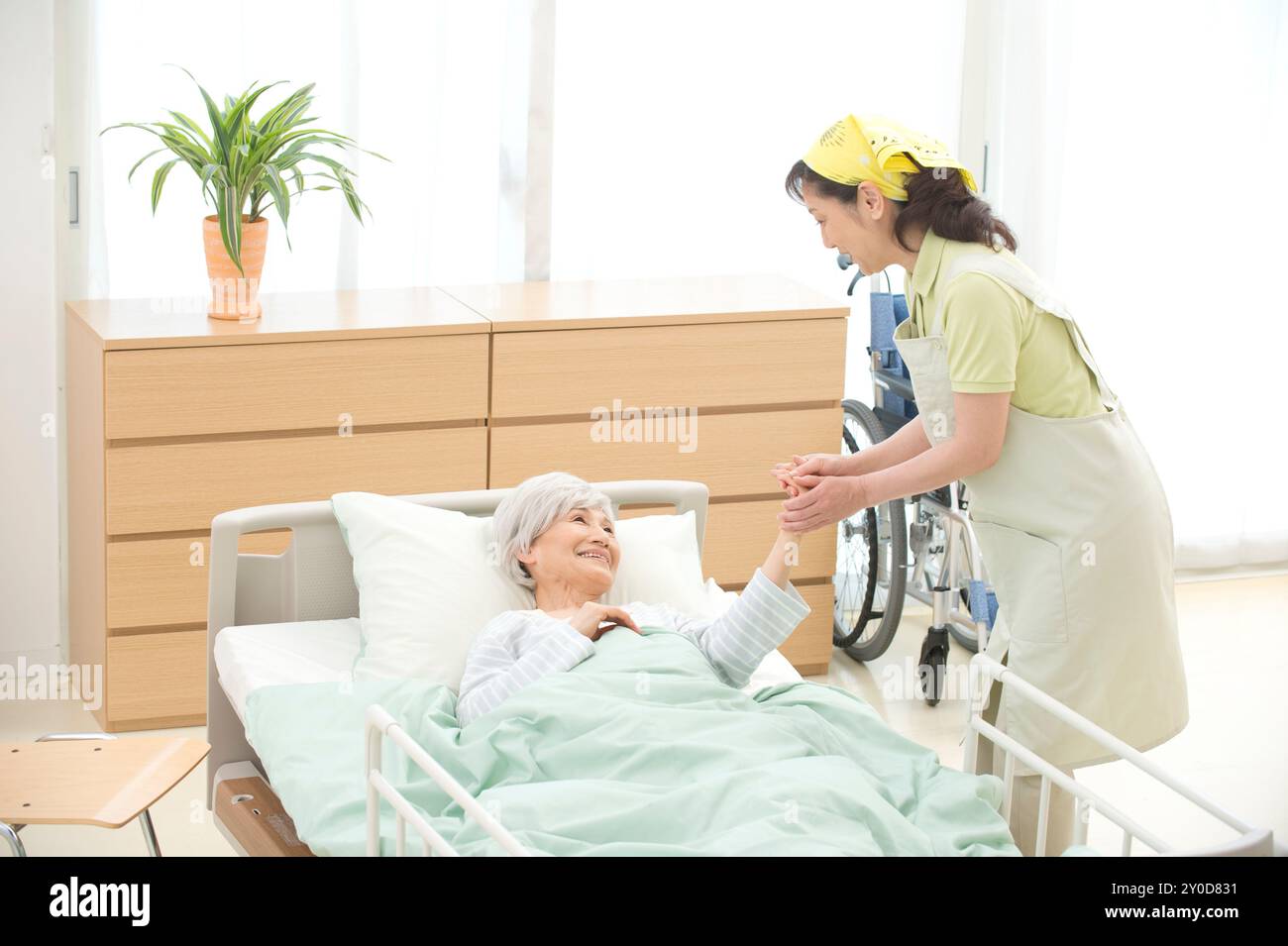 An elderly in bed and a care helper Stock Photo - Alamy