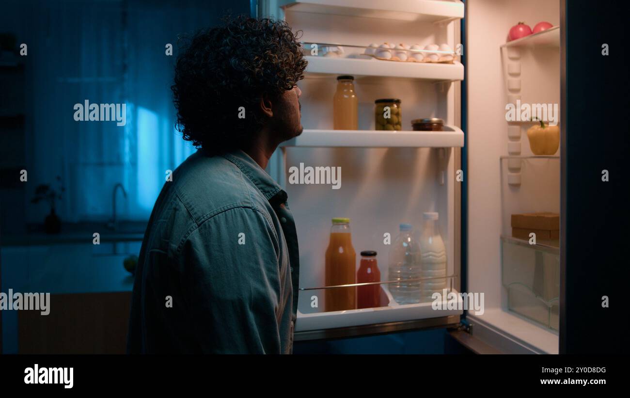 Home kitchen at night dark room hungry Hispanic man Indian male guy ...