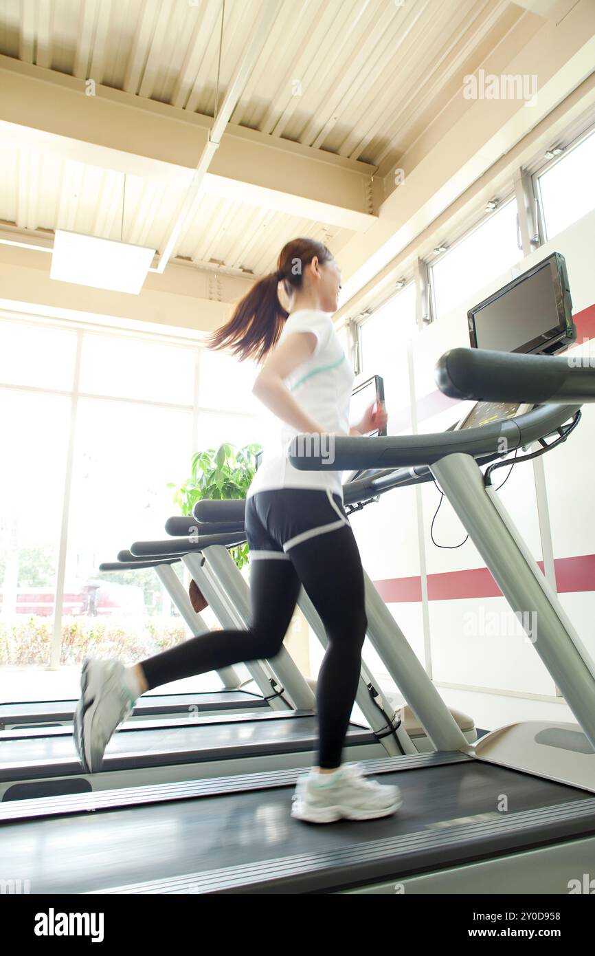 Woman running on a treadmill and 30s hi-res stock photography and ...
