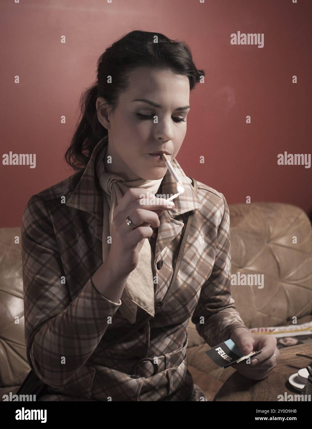 Woman smoking a cigarette in a chequered jacket Stock Photo - Alamy