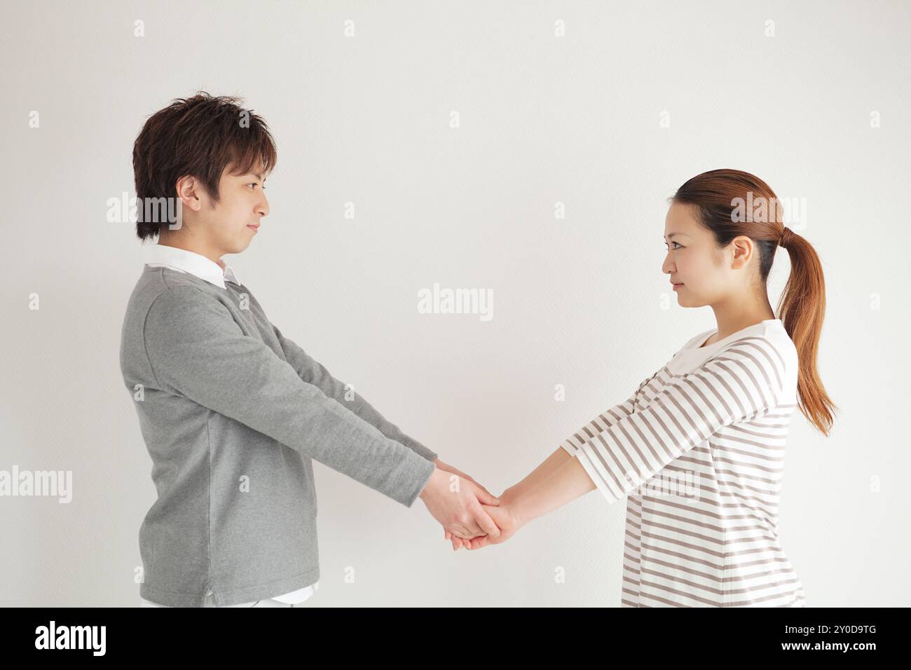 Couple staring at each other while hand in hand Stock Photo - Alamy