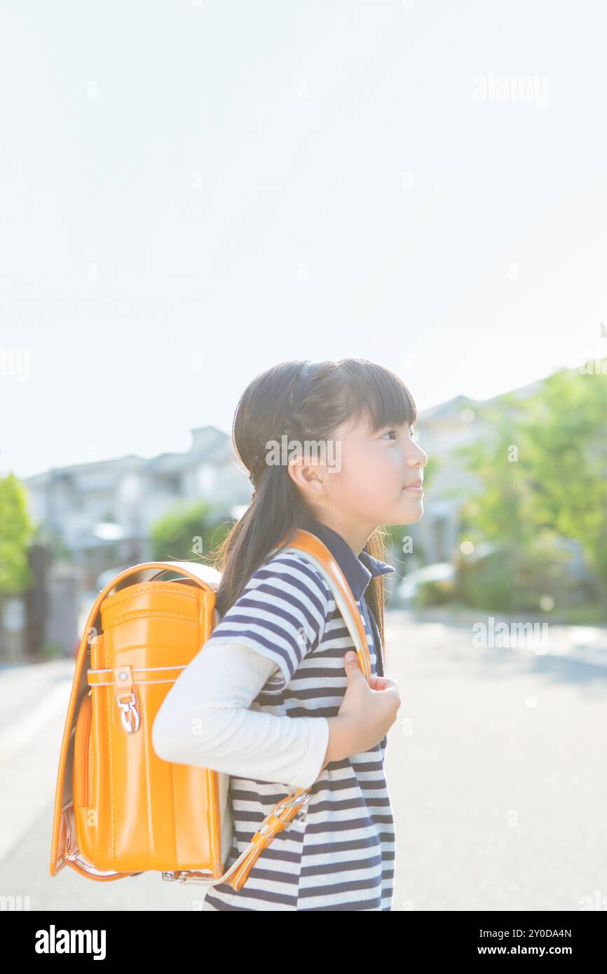 Elementary school girl carrying satchel on her back Stock Photo - Alamy