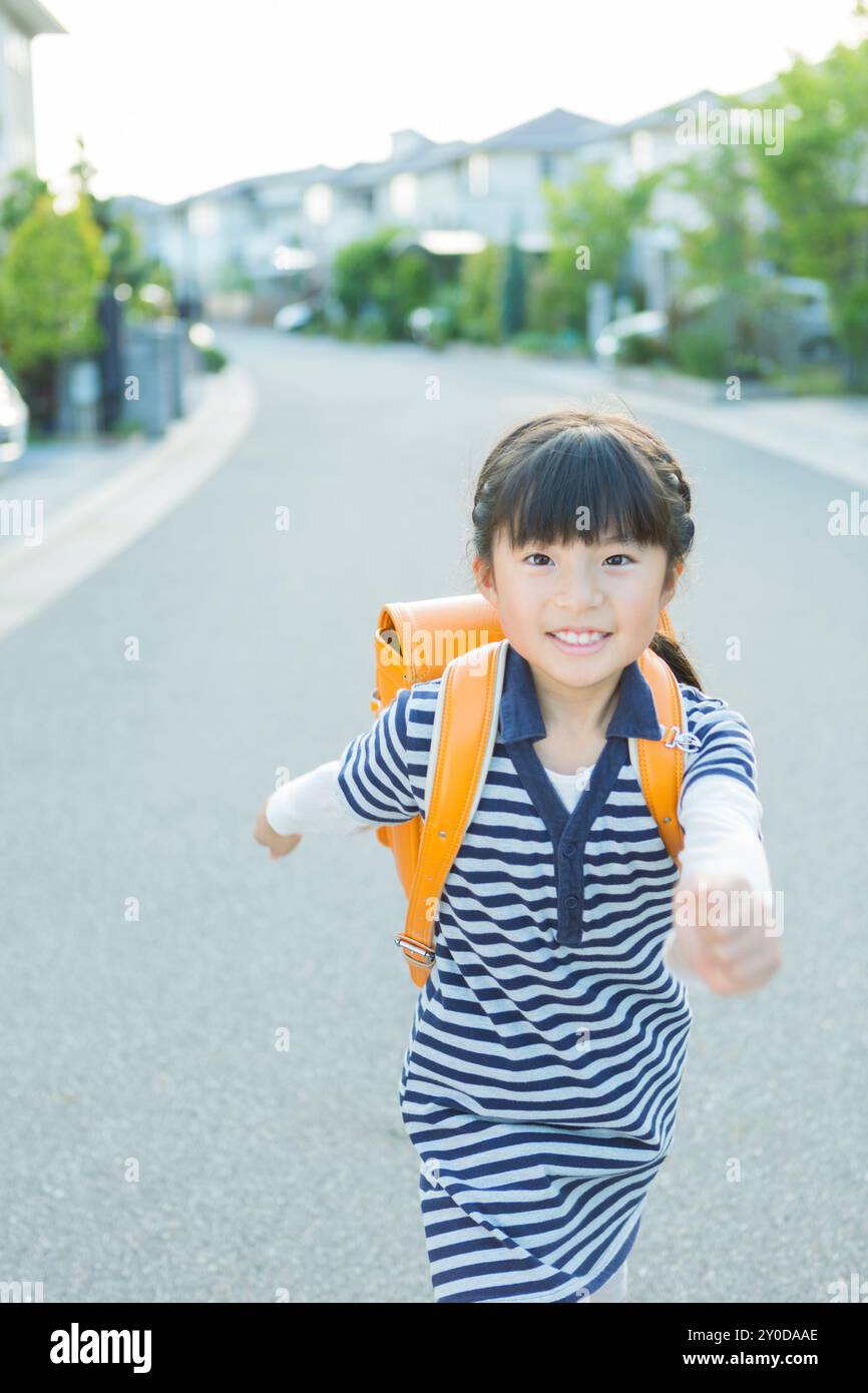 Elementary school girl carrying satchel on her back Stock Photo - Alamy