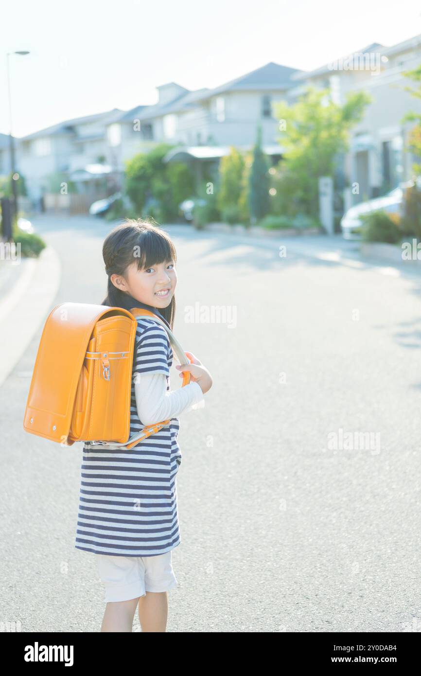 Elementary school girl carrying satchel on her back Stock Photo - Alamy