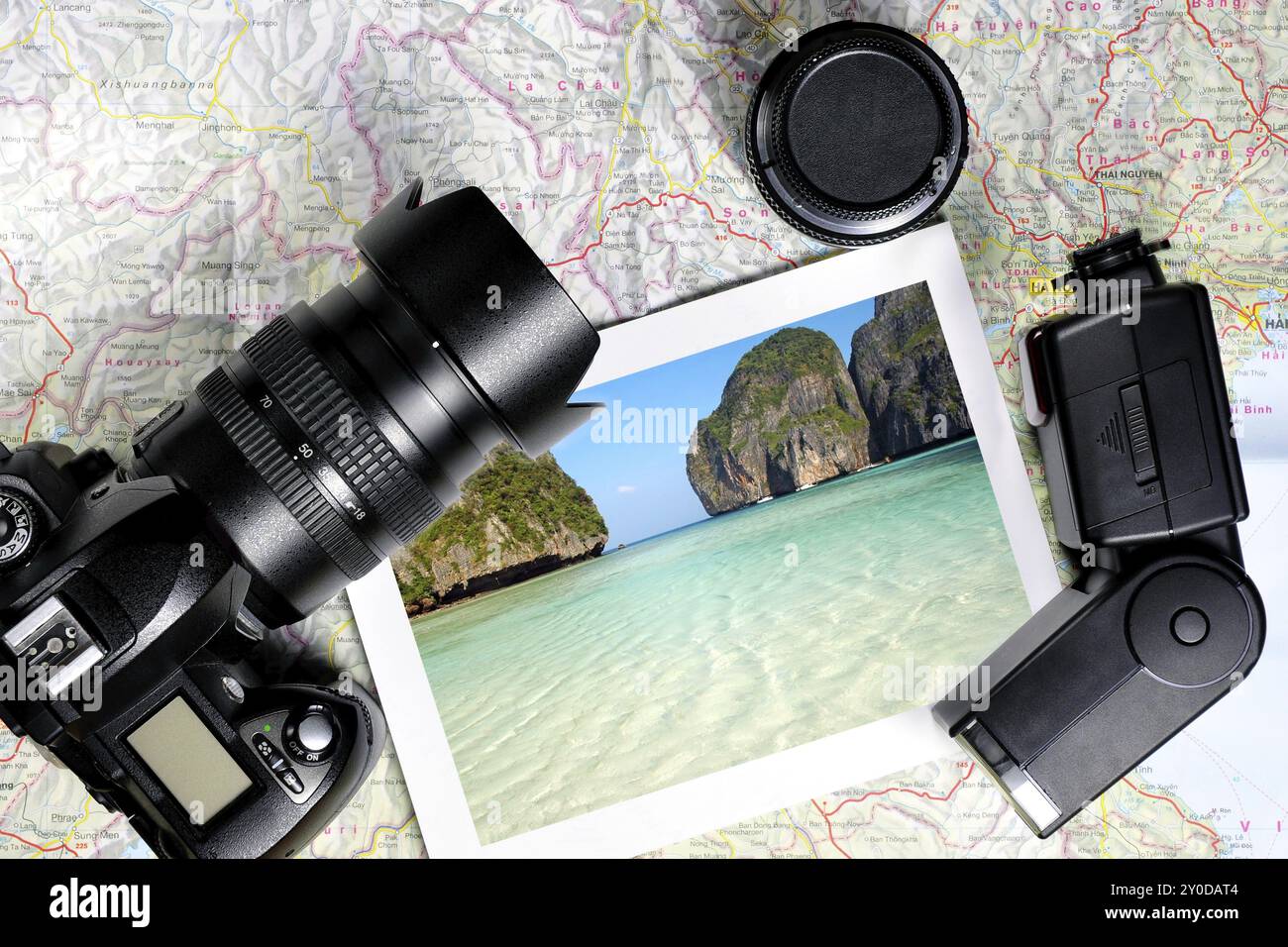 Digital camera, lens, flash and a photo layed on top of a map of ...