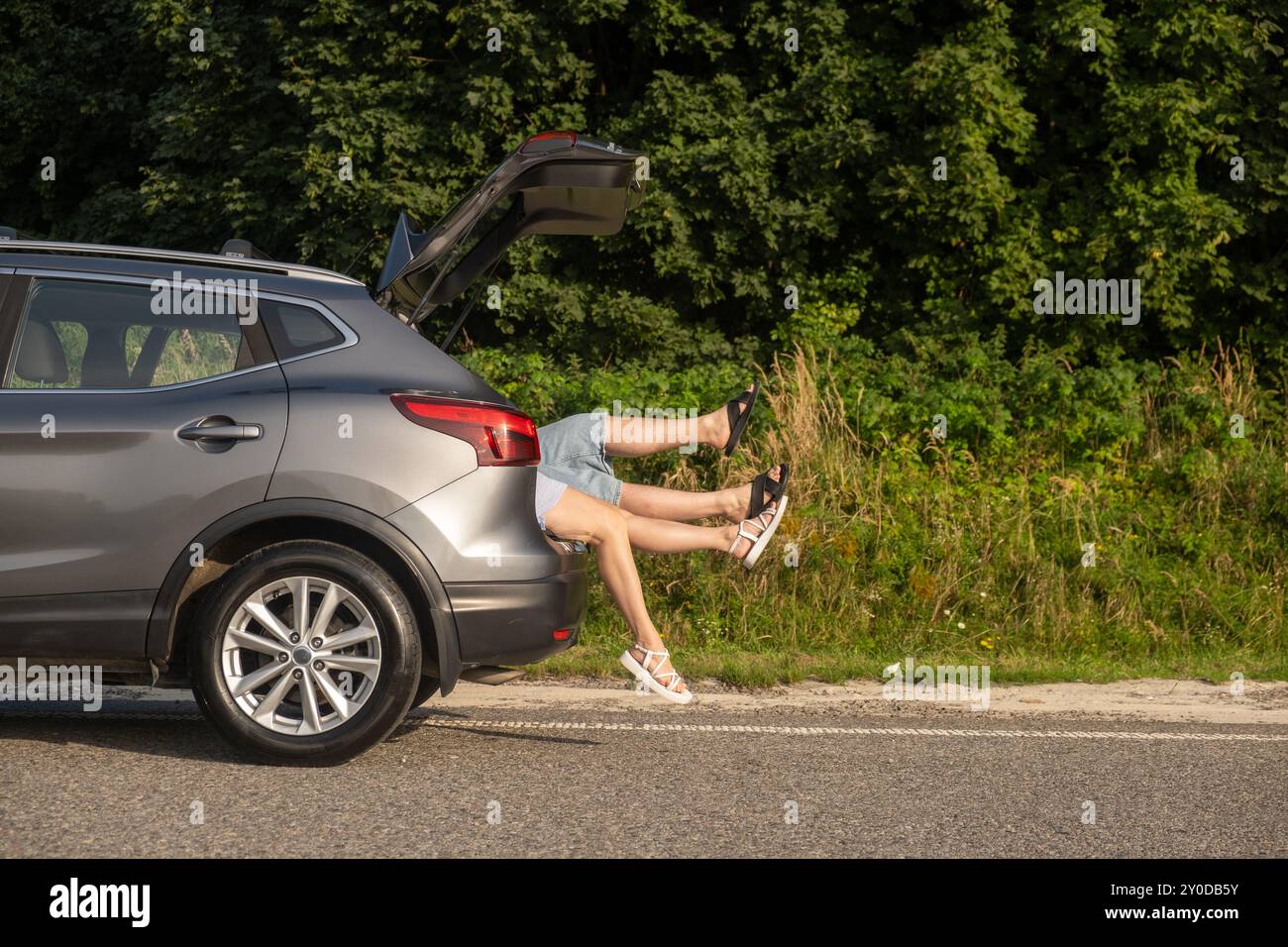 Humorous Scene of Legs Sticking Out from SUV Trunk Road Trip Stock ...