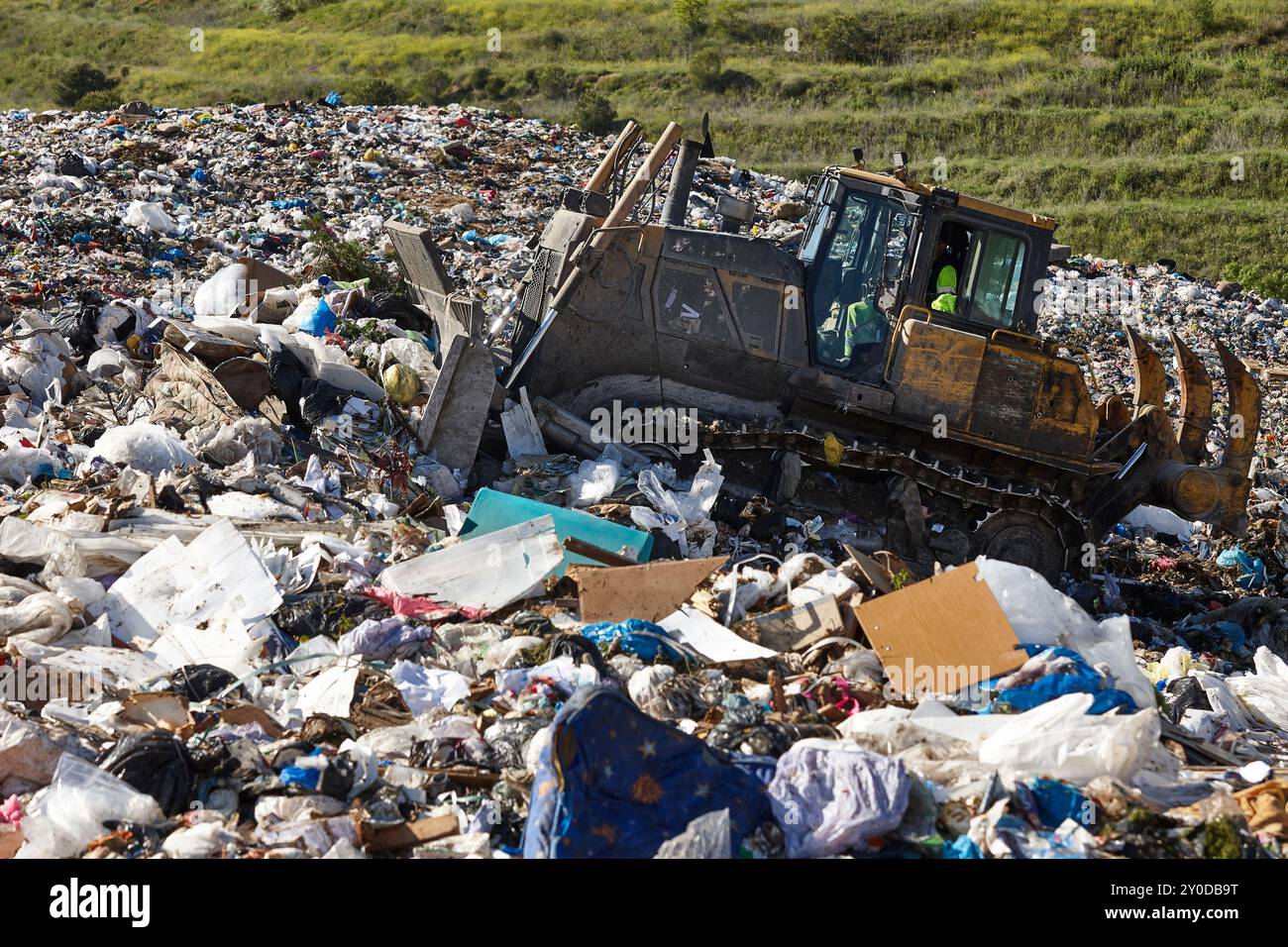 Heavy machinery shredding garbage in an open air landfill. Waste Stock ...