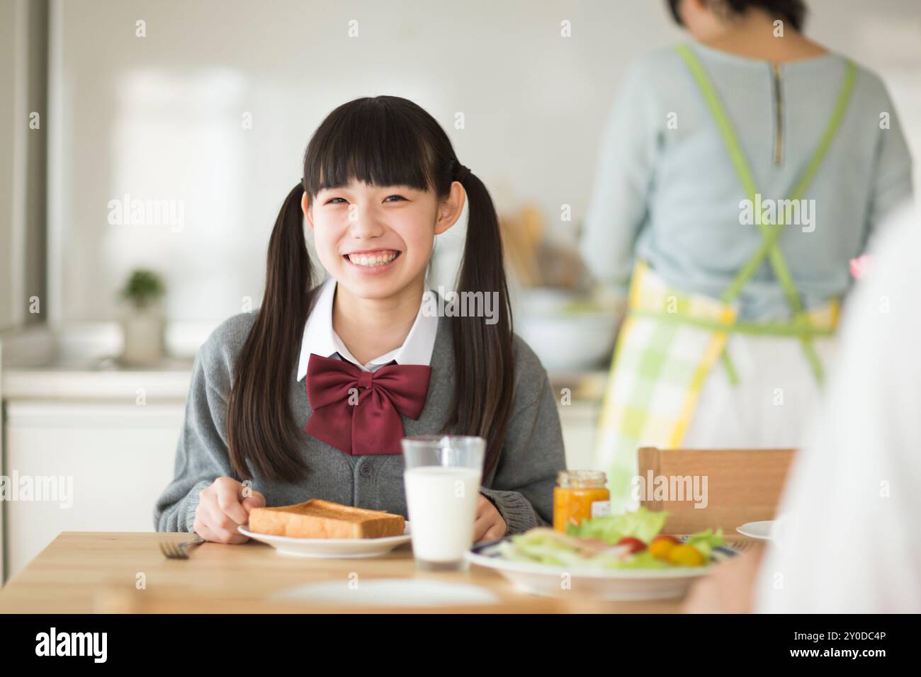 A girl sitting on the dining table Stock Photo - Alamy