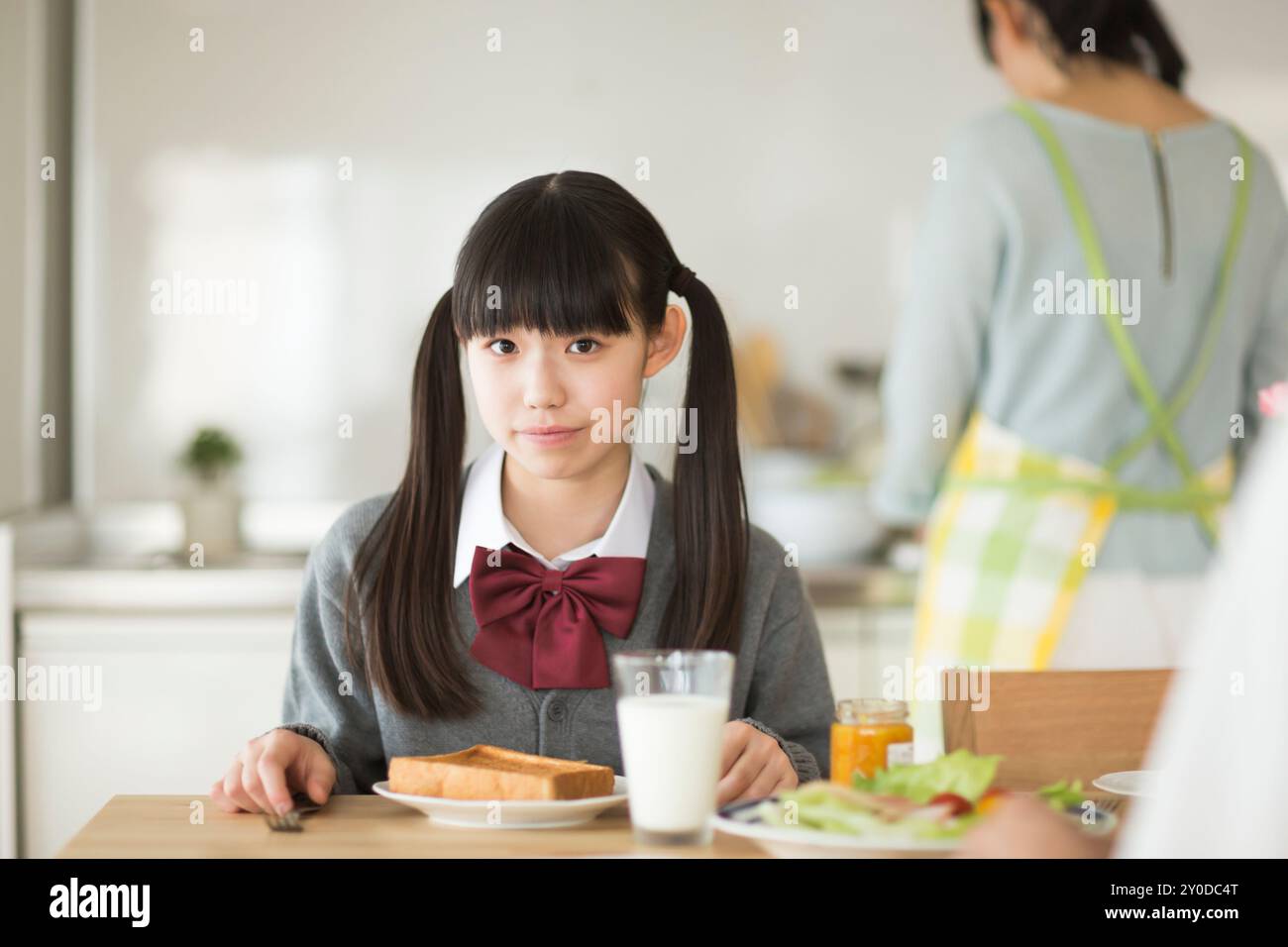 A girl sitting on the dining table Stock Photo - Alamy