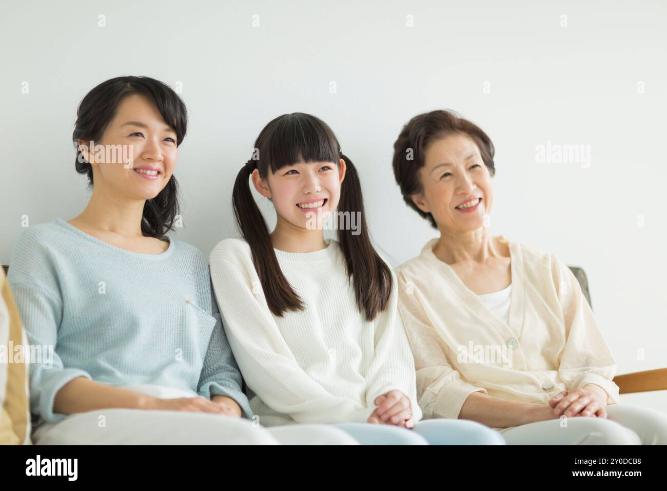 Family of three generations sitting on a sofa Stock Photo - Alamy