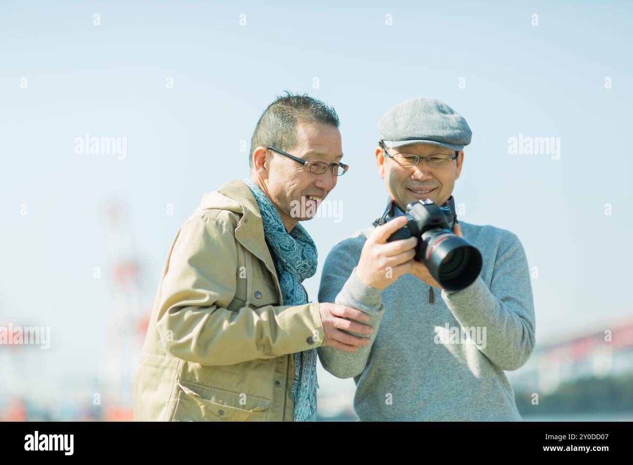 An elderly man looking at a single lens reflex camera Stock Photo - Alamy