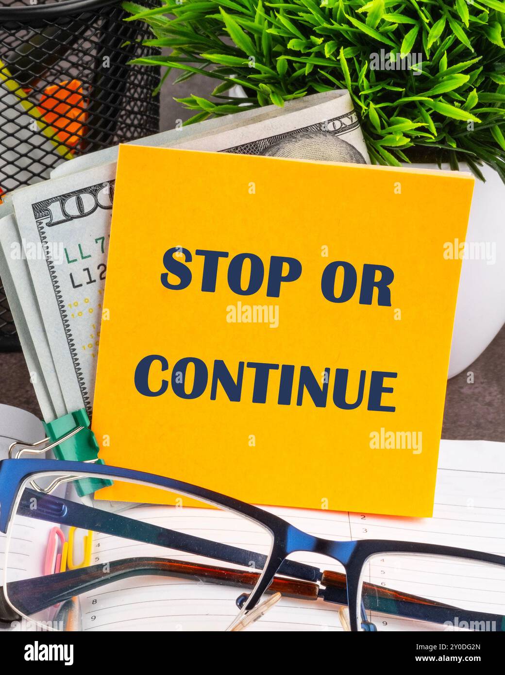 STOP OR CONTINUE written on a yellow sticker, vertical concept photo ...
